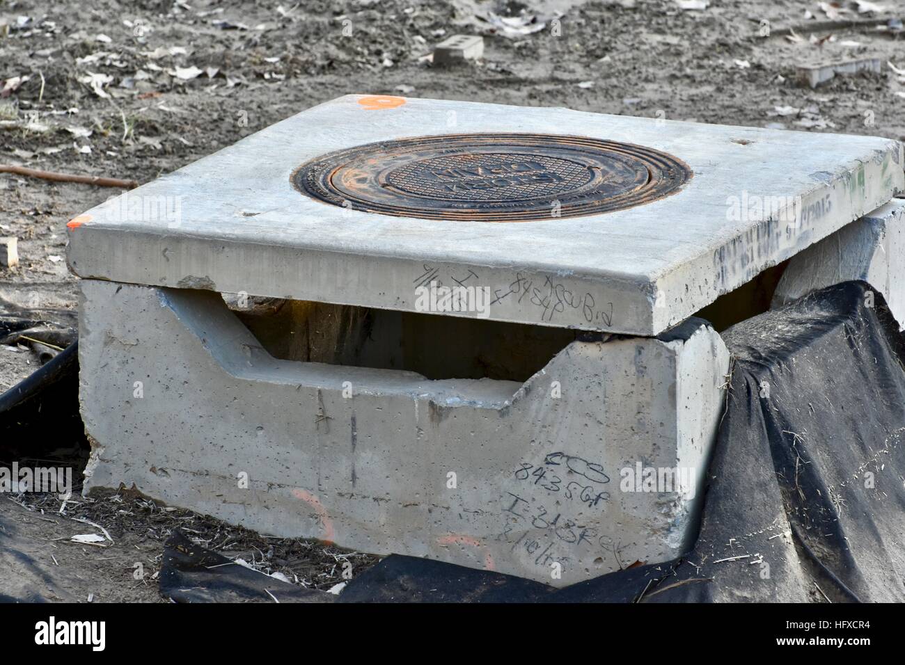 A covered manhole with an exposed opening for the storm drain Stock ...