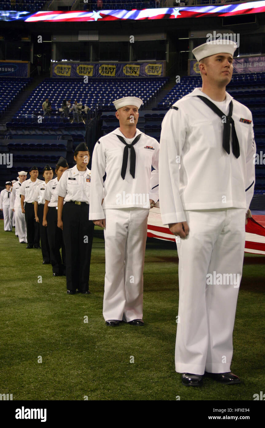 Sailors, Sea Cadets, and Junior ROTC students hold a ceremonial flag ...
