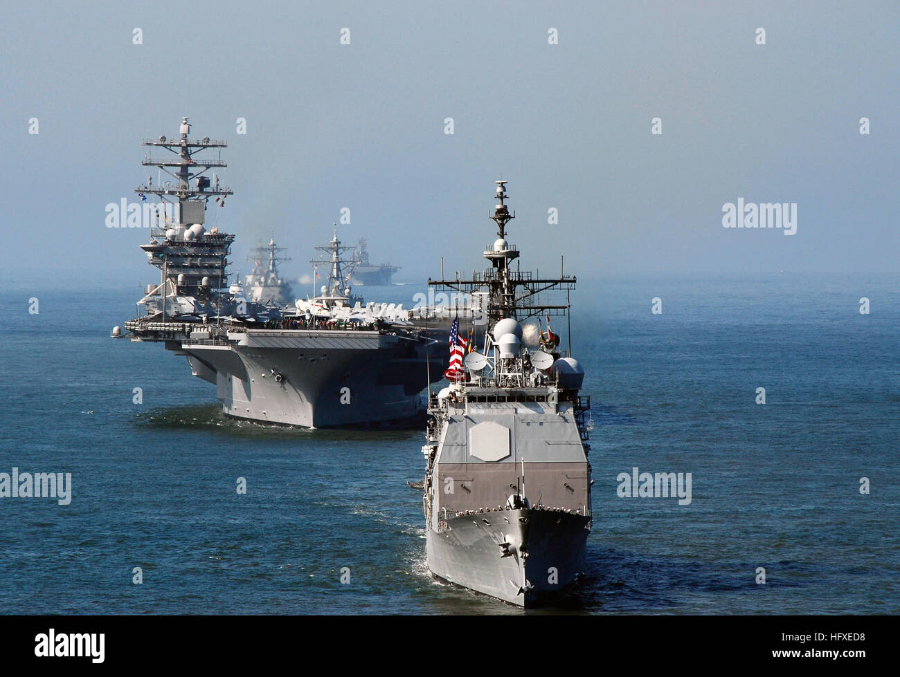 A parade of ships led by the U.S. Navy Ticonderoga Class Guided Missile ...