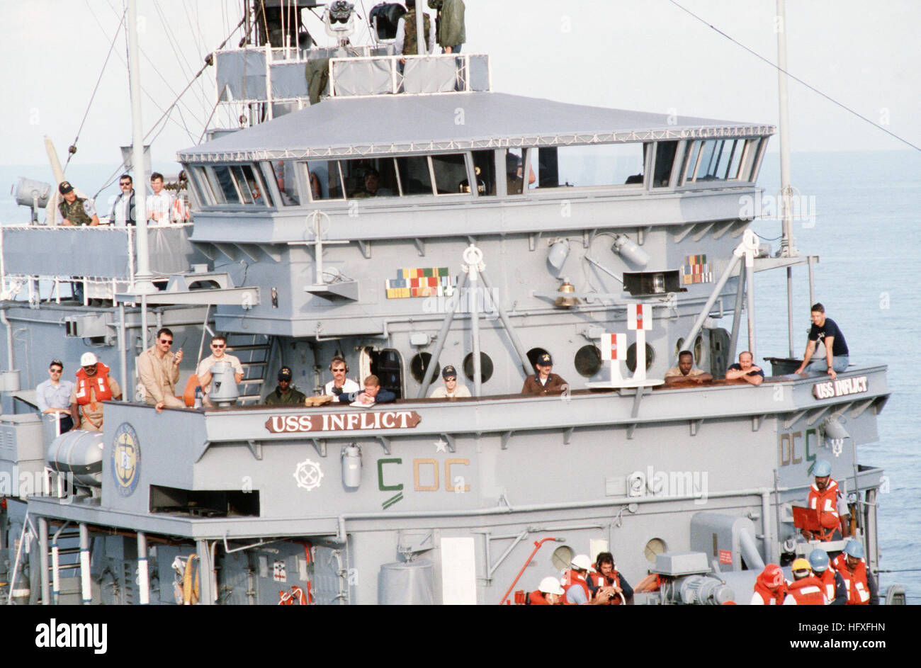 Crew members watch from the bridge of the ocean minesweeper USS INFLICT ...