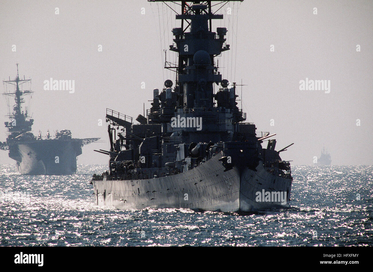 A starboard bow view of the battleship USS WISCONSIN (BB-64) followed ...