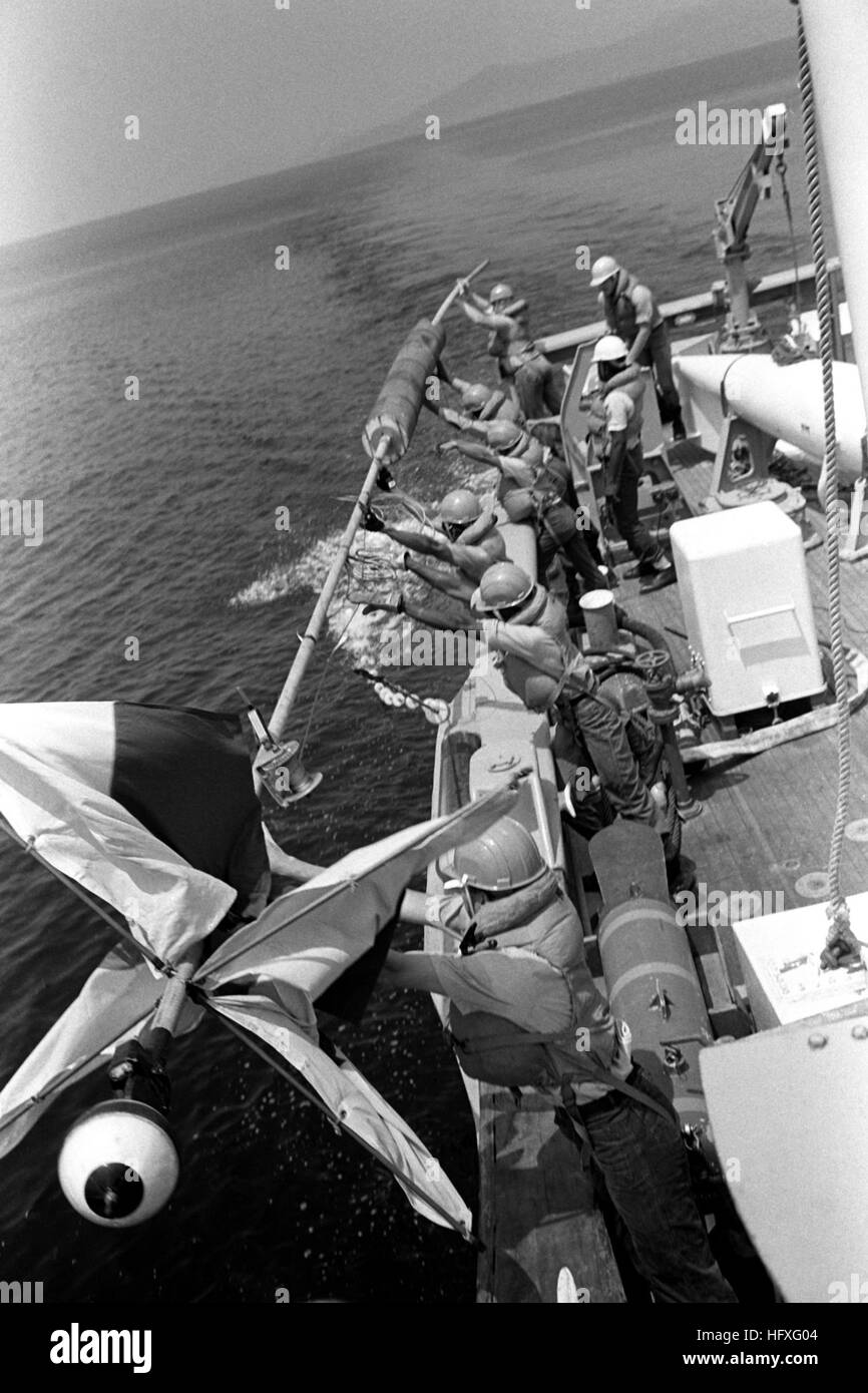 Crewmen of the ocean minesweeper USS ESTEEM (MSO 438) maneuver a high ...