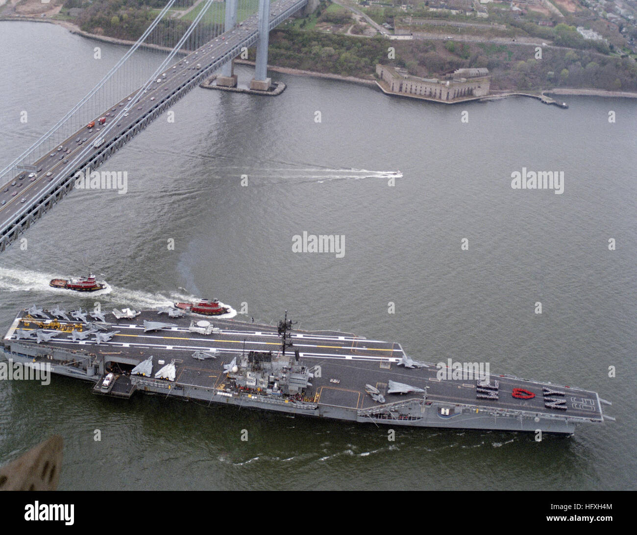 The aircraft carrier USS FORRESTAL (CV 59), escorted by a pair of tug ...