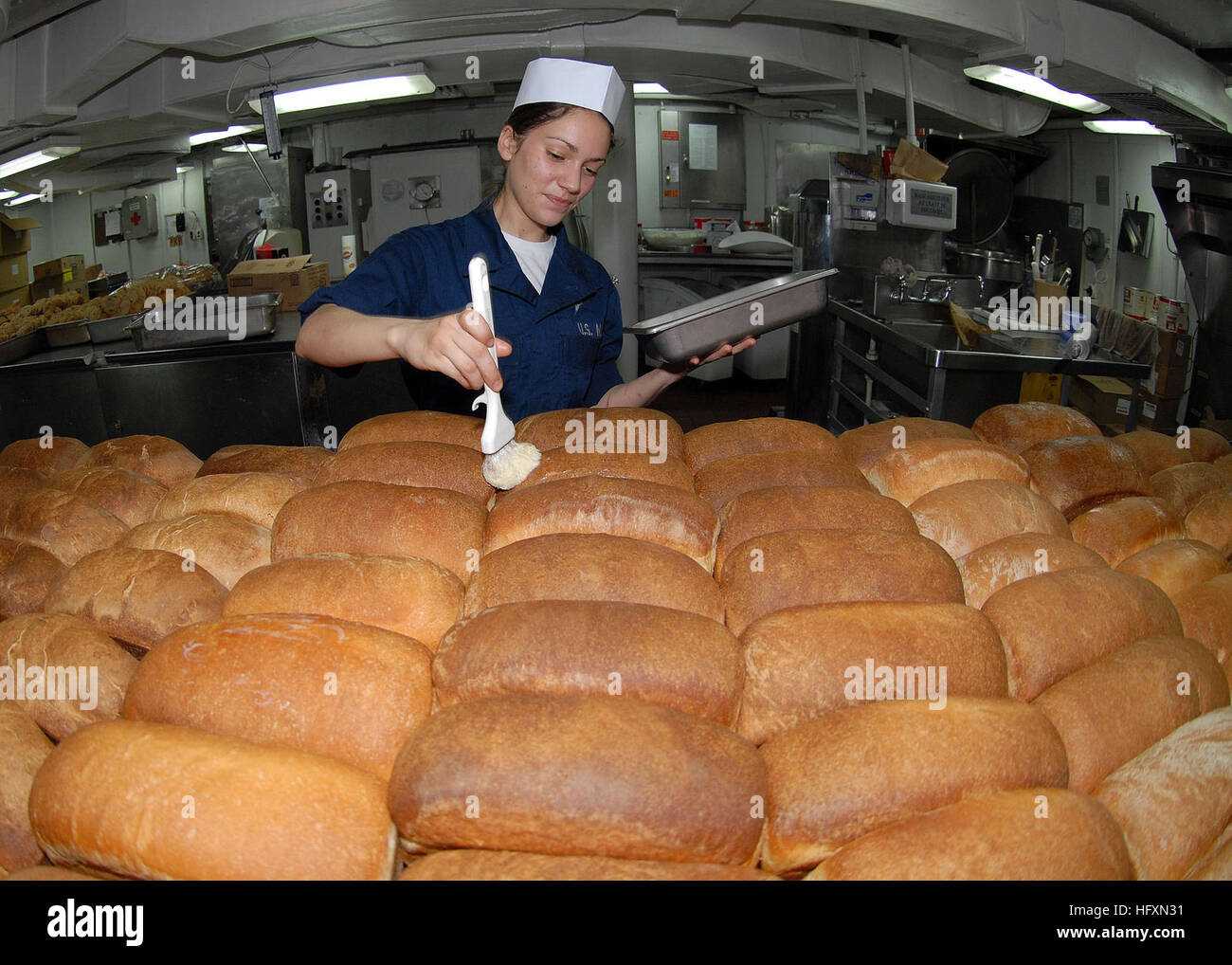 A Culinary Specialist prepares fresh baked bread aboard the aircraft ...