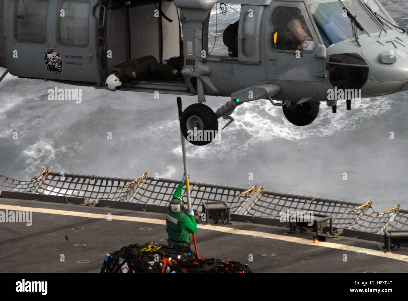 A crewmember aboard the USNS Rainier conducts a replenishment at sea ...