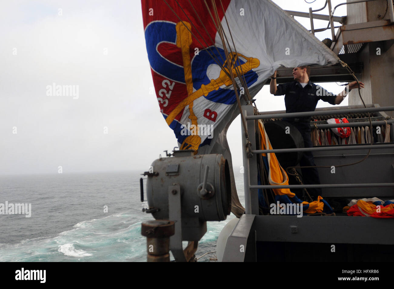 USS Ronald Reagan (CVN 76) lowers the battle flag after a replenishment ...