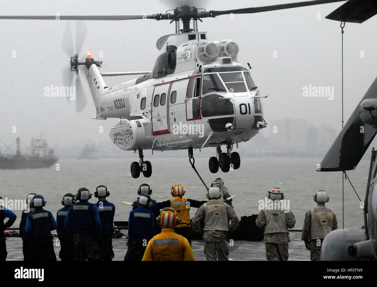 Sailors and Marines aboard the amphibious dock landing ship USS Harpers ...