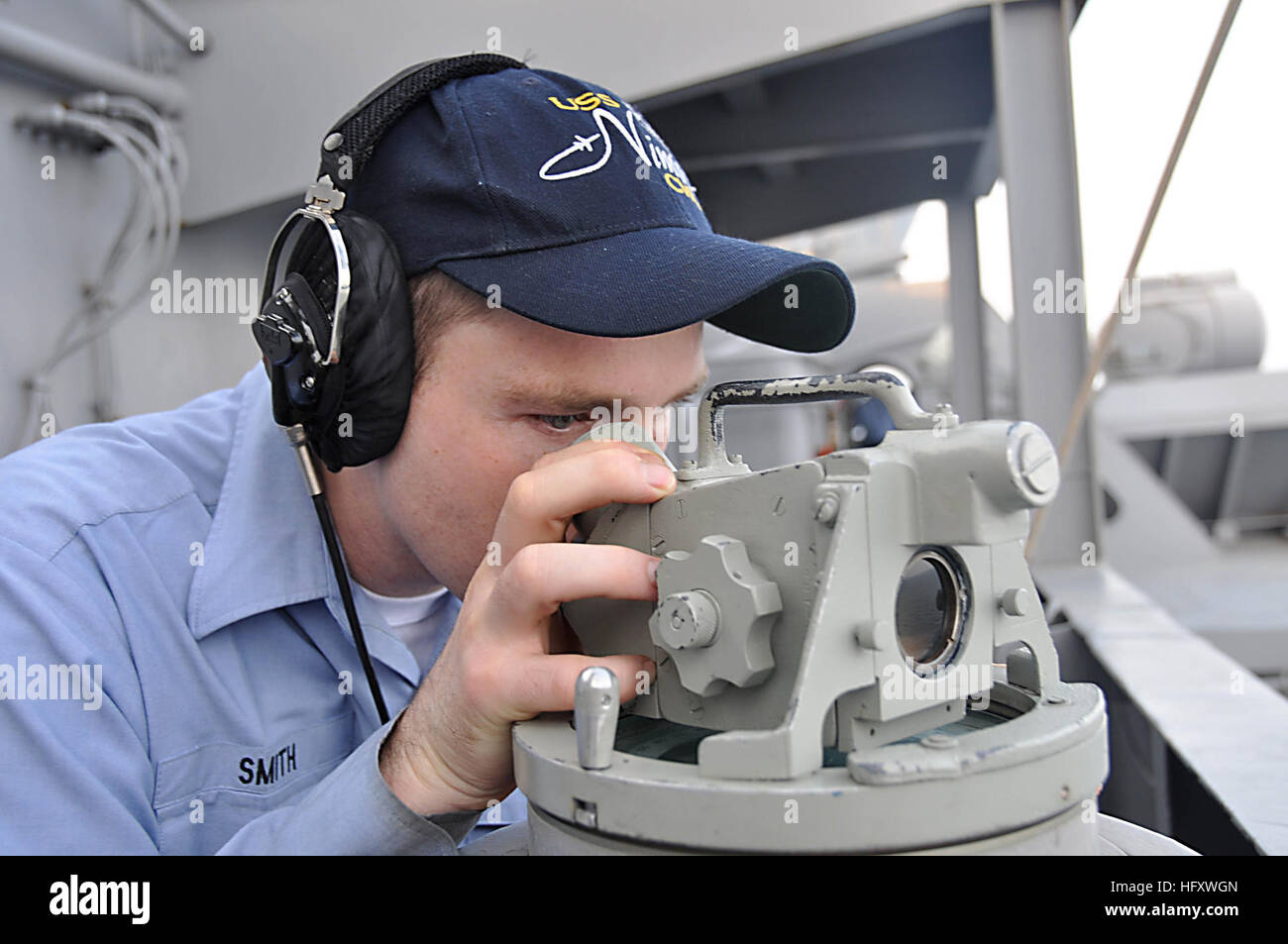 Seaman Apprentice Justin Smith takes a bearing on a telescopic alidade ...