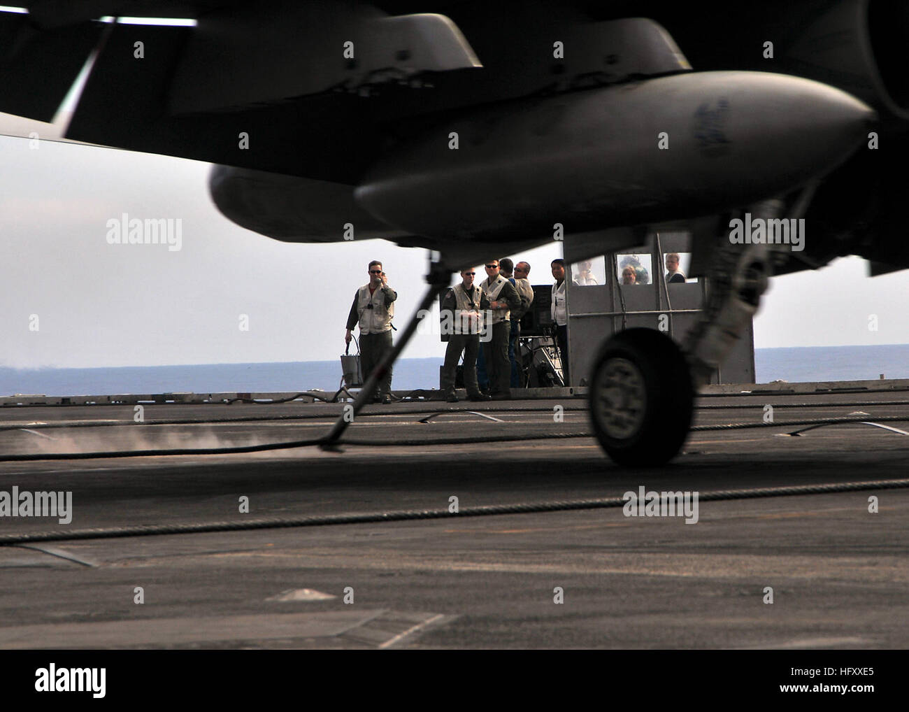 Landing signal officers observe an F/A-18C Hornet, assigned to the ...