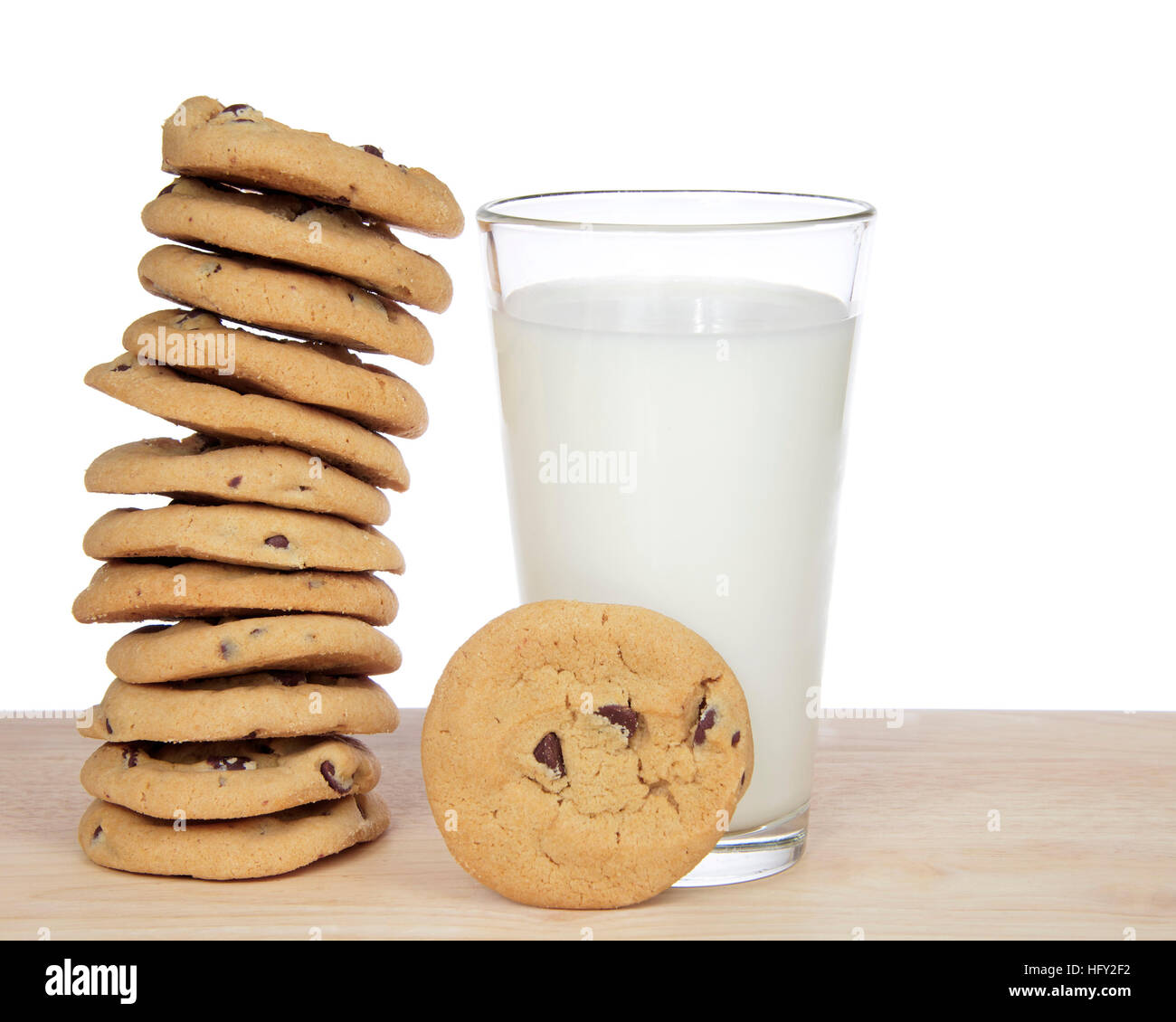 Stack of 12 chocolate chip cookies precariously stacked next to a glass ...
