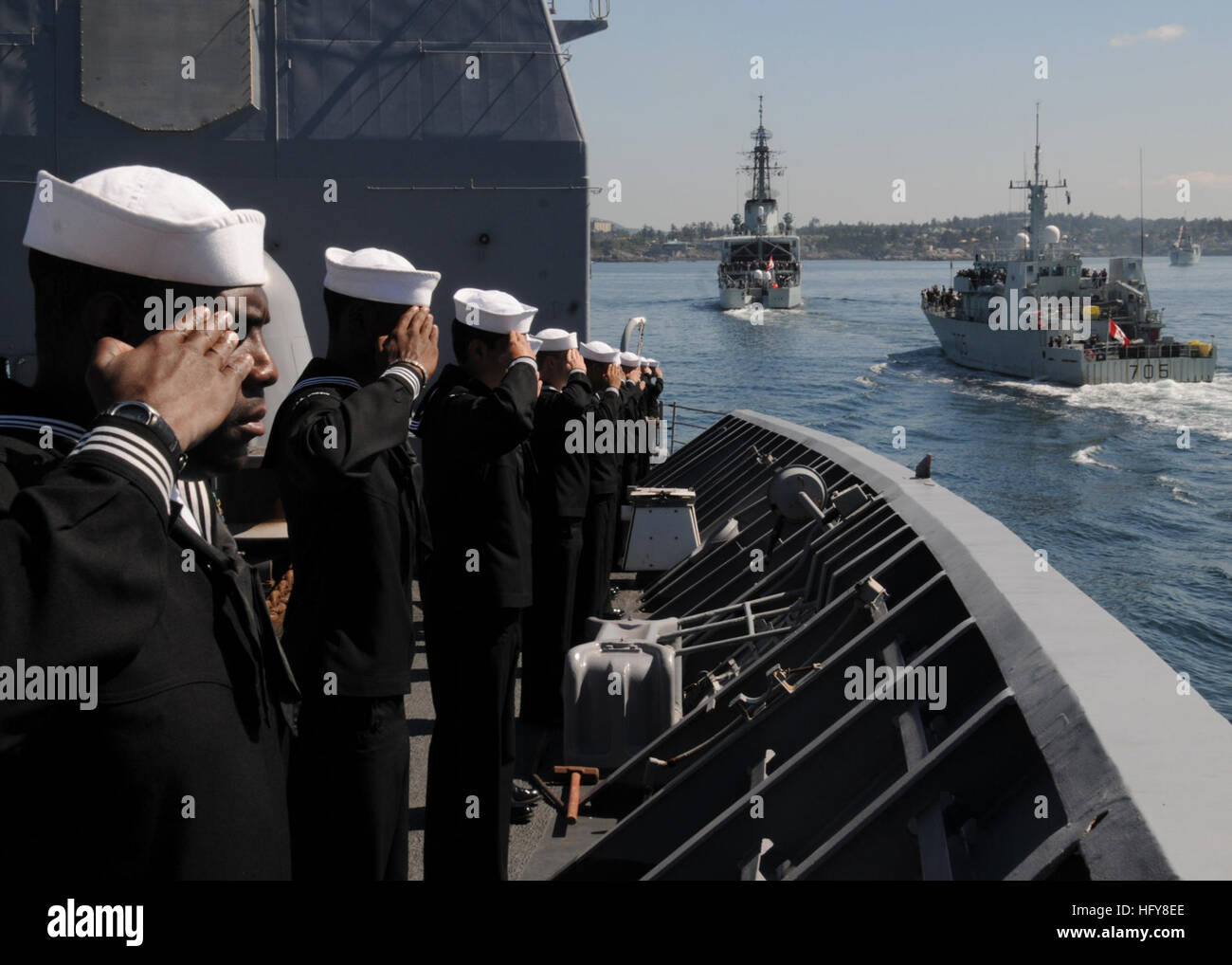 Sailors aboard the guided-missile cruiser USS Chosin render passing ...
