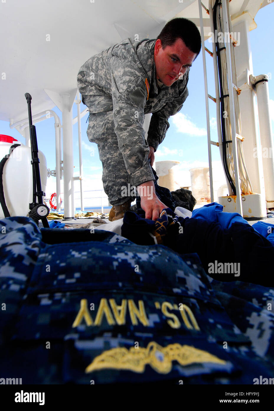 Army Spc. James Wood sprays service working uniforms and clothing with ...