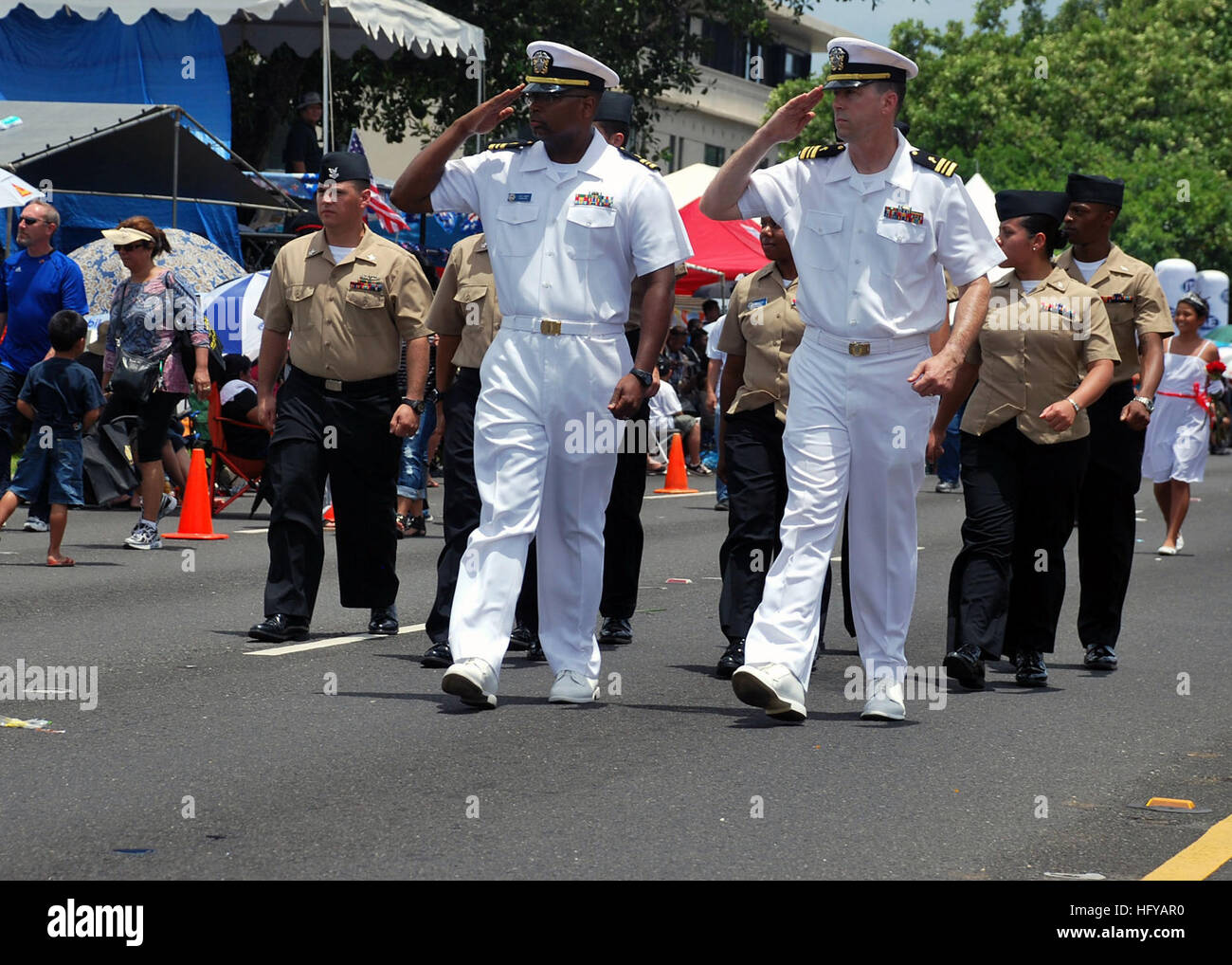 Sailors aboard the submarine tender USS Frank Cable render honors to ...