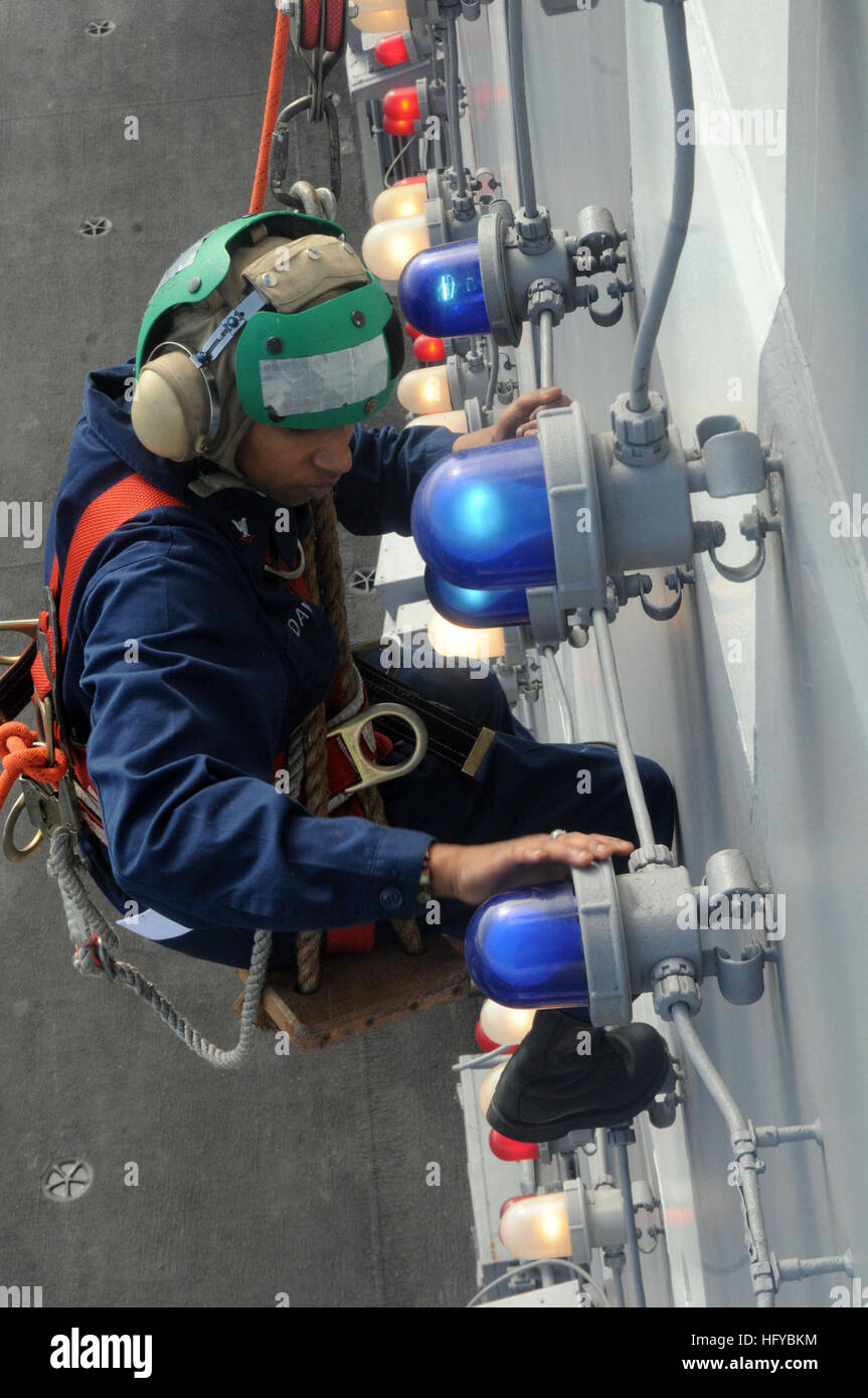 An Electrician's Mate aboard USS Ronald Reagan (CVN 76) replaces a ...
