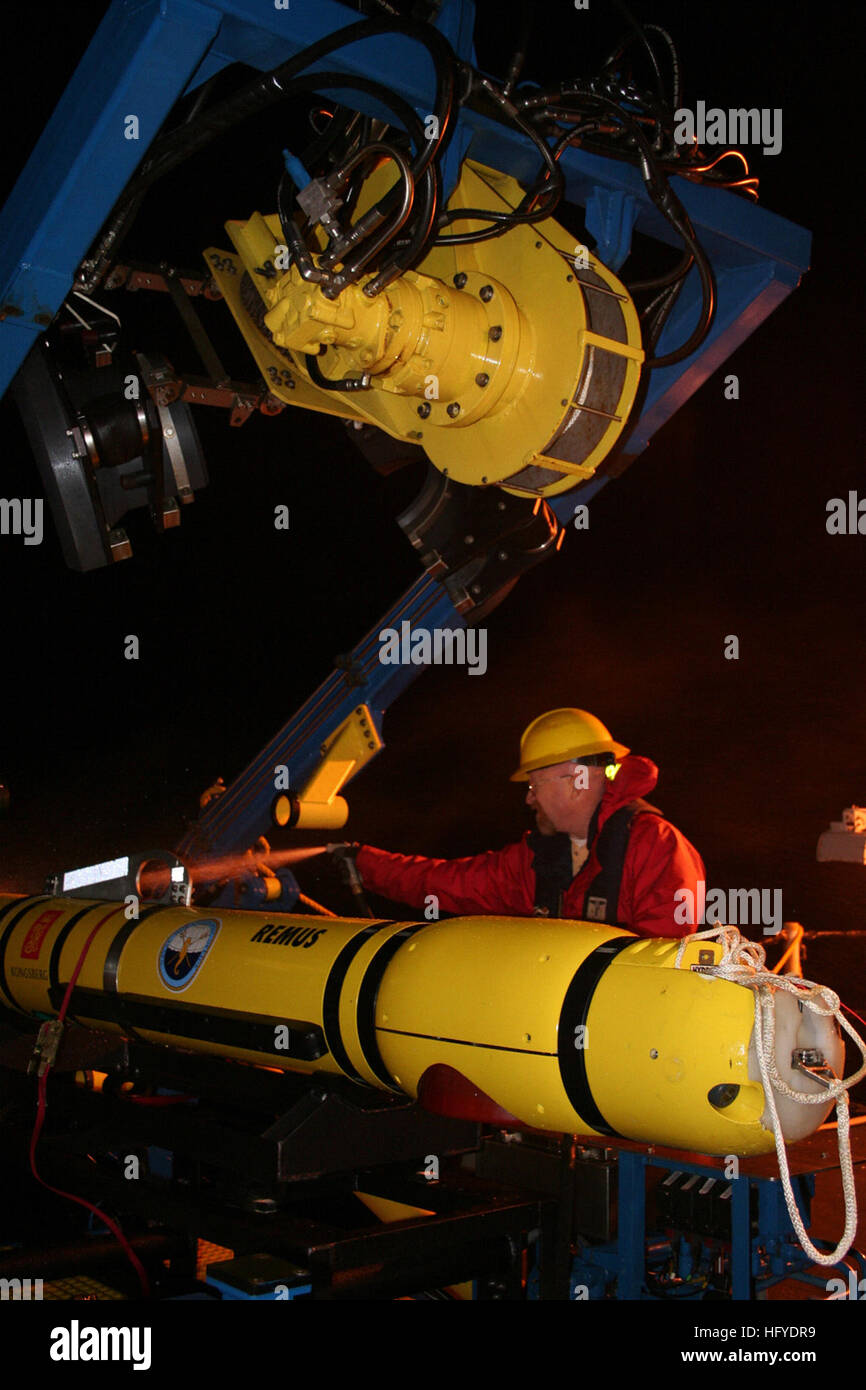 Personnel aboard the survey ship USNS Henson recover and rinse an ...