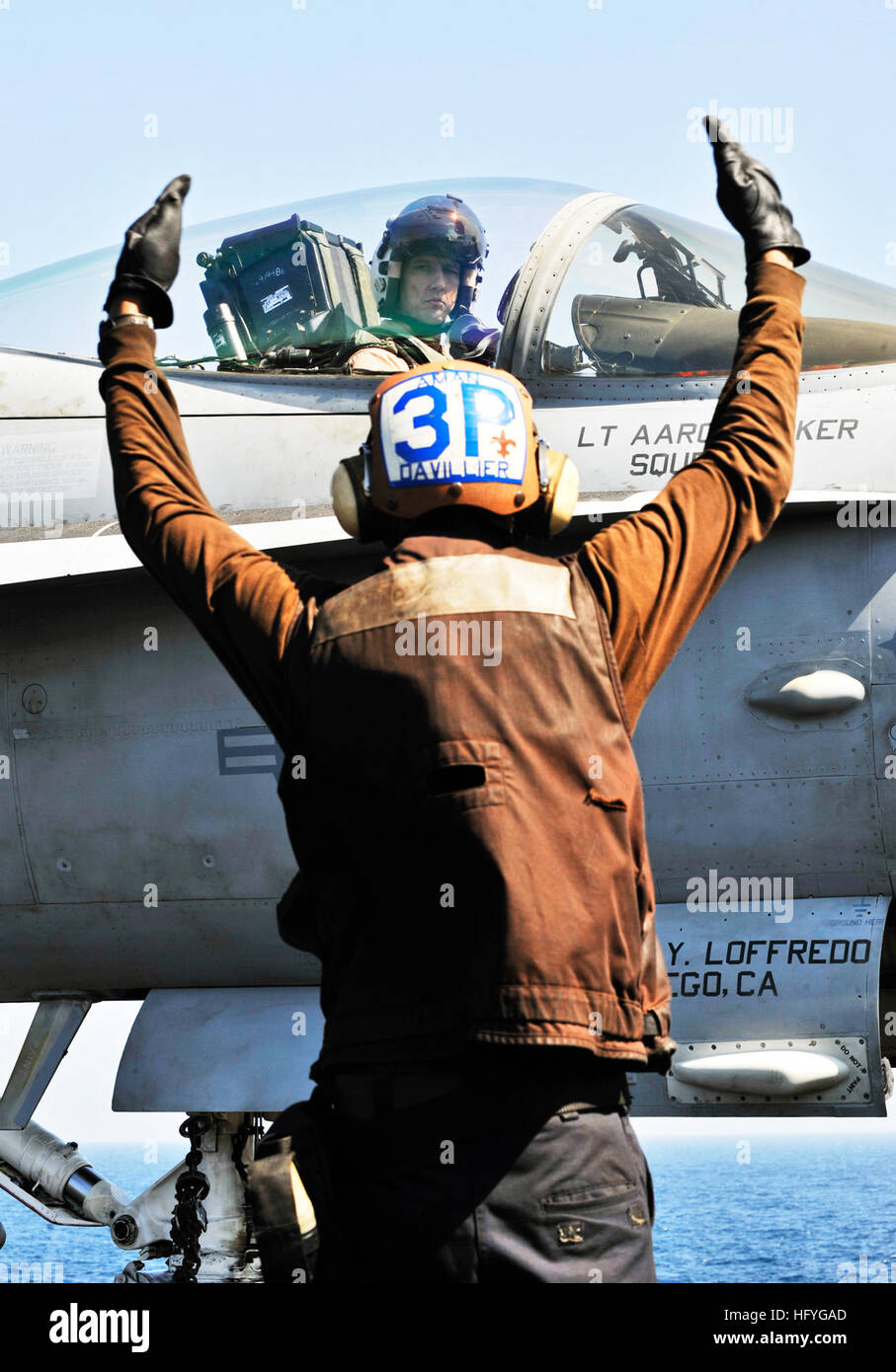 Capt. James Bynum, commander of Carrier Air Wing 3, looks to his plane ...