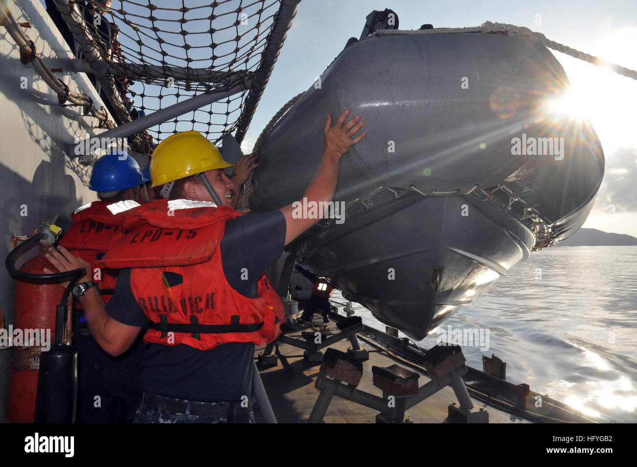 Crew members aboard amphibious transport dock USS Ponce guide a 7-meter ...