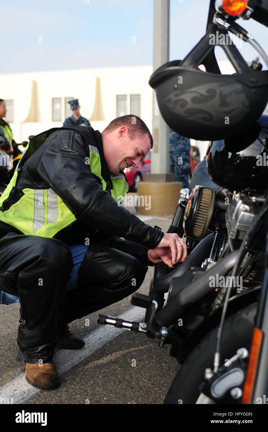 Petty Officer 1st Class Randy Watson checks his motorcycle's oil level ...