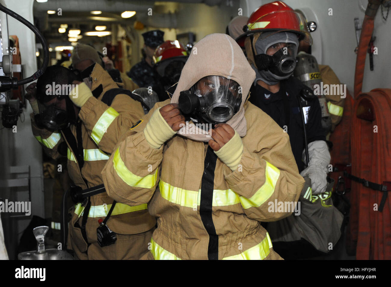 Fire party members aboard USS Makin Island (LHD 8) wear firefighting ...
