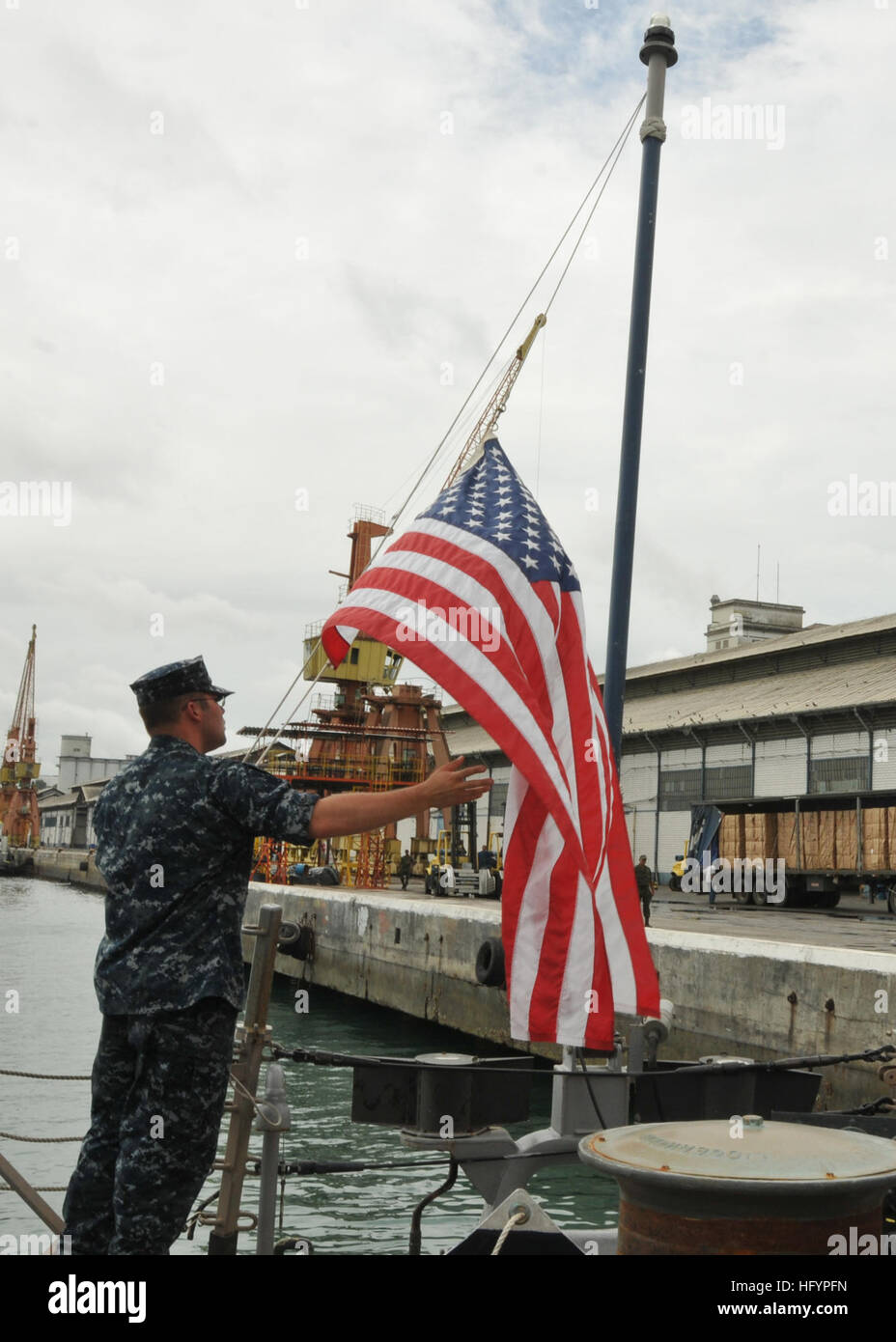 USS Thach (FFG 43) lowers the national ensign on the fantail while ...
