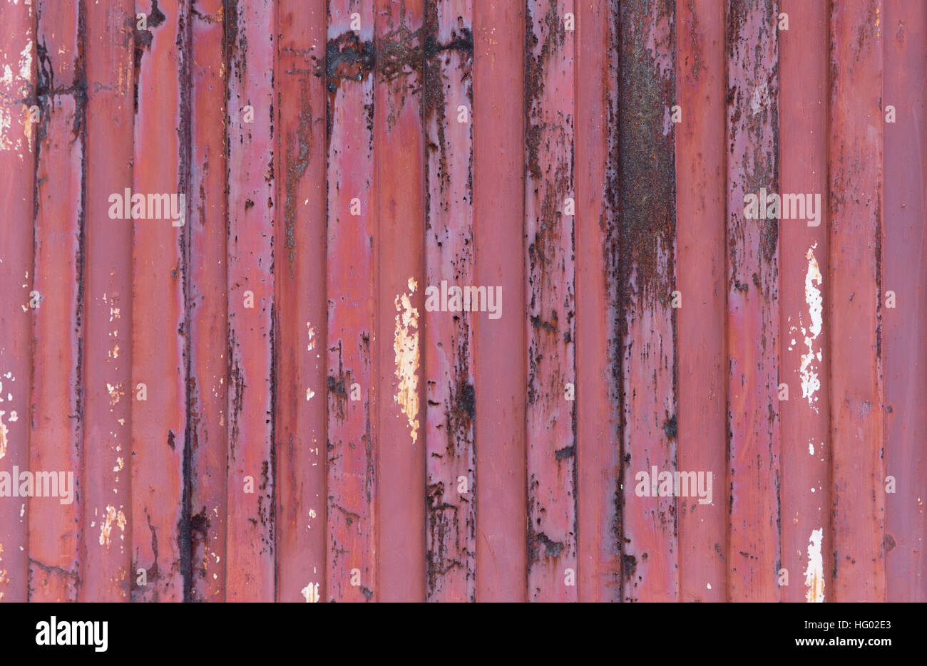 Stained red metal wall with vertical lines. Horizontal indoors shot ...