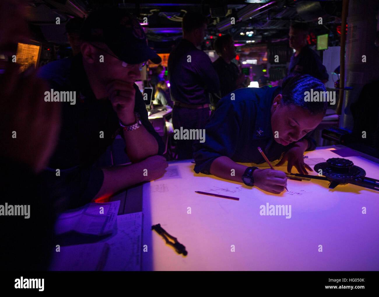 Petty Officers plot navigational points on a chart in the combat ...