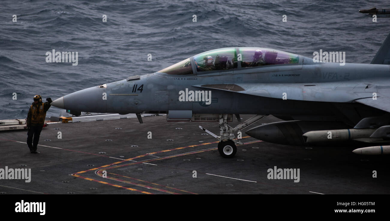 An aircraft director stands by an F/A-18F Super Hornet aboard USS ...