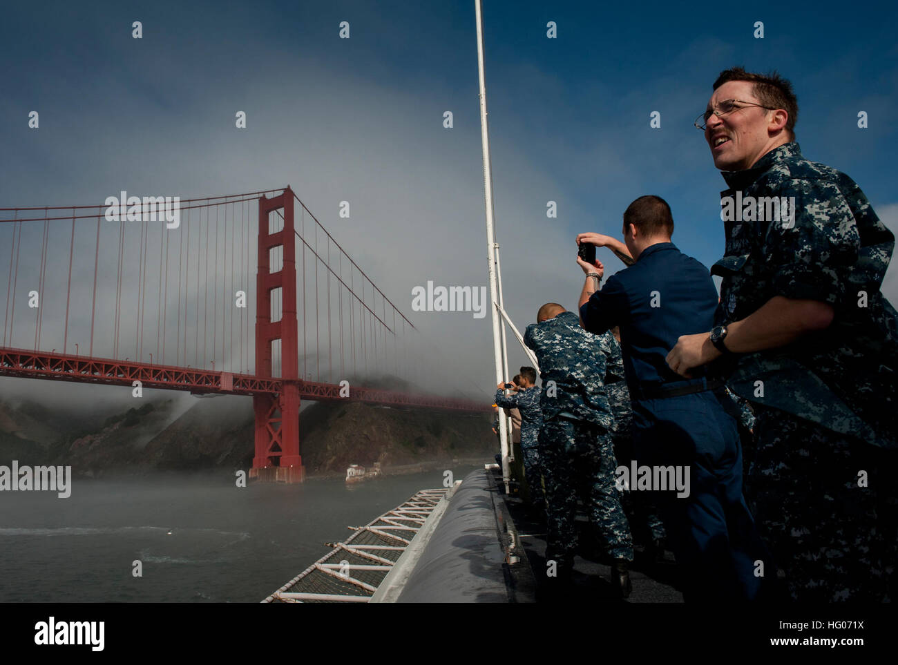 Sailors watch from the flight deck as the Nimitz-class aircraft carrier ...