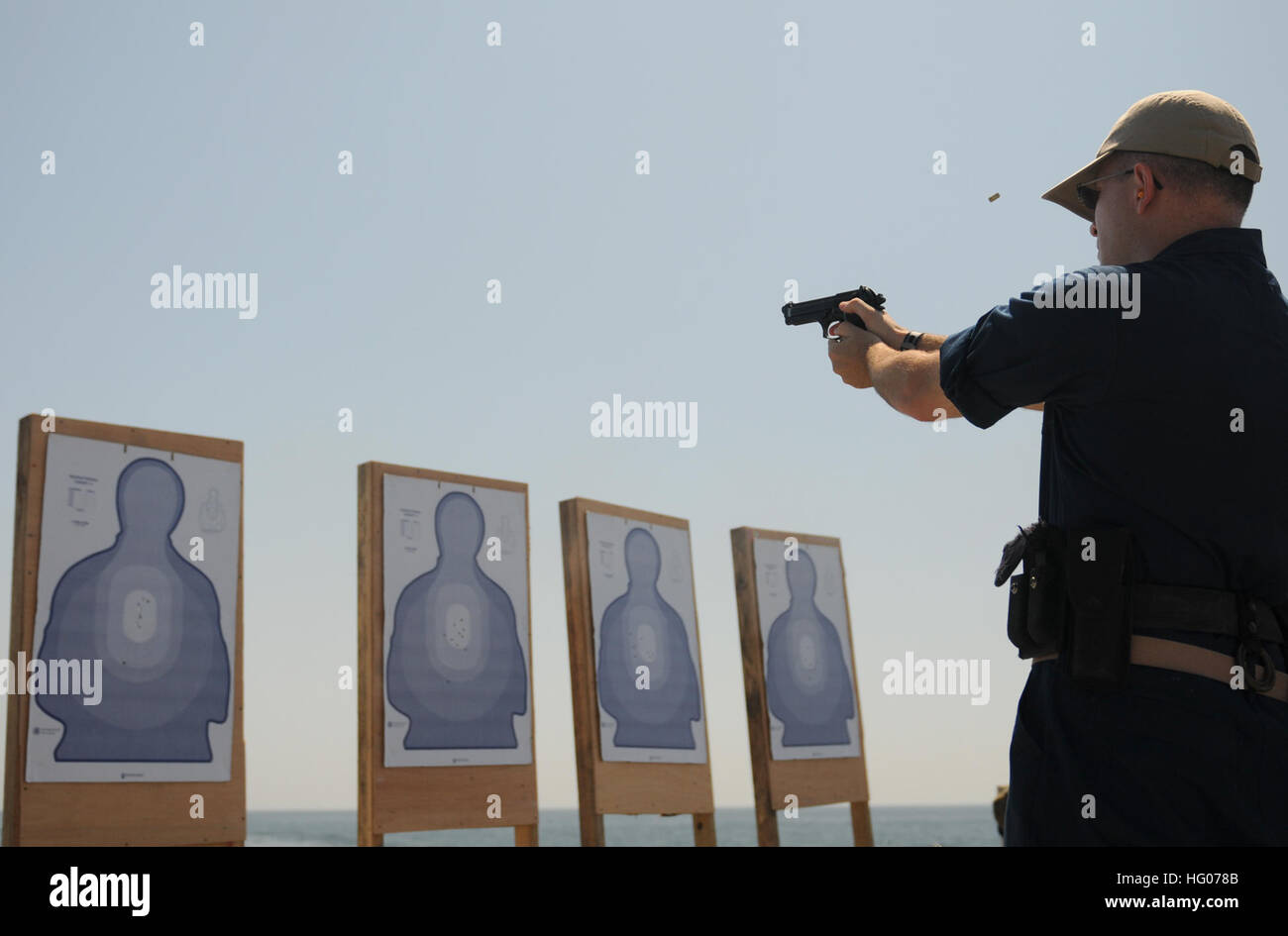 Electronic materials officer fires a 9mm pistol during a small arms ...