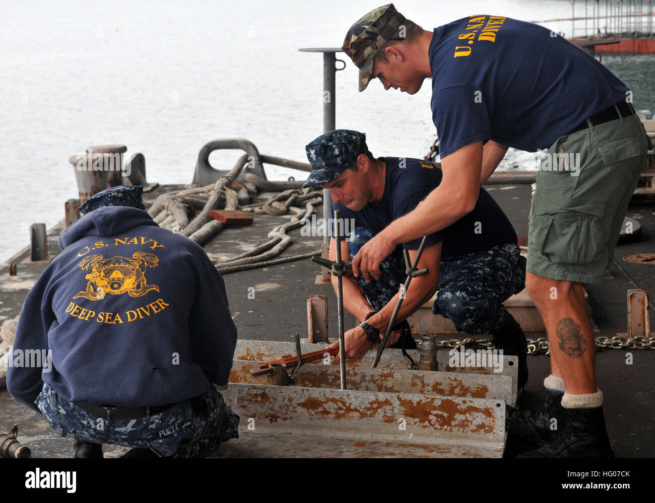 Navy divers inspect and attach a cofferdam to the hull of USS Nimitz ...