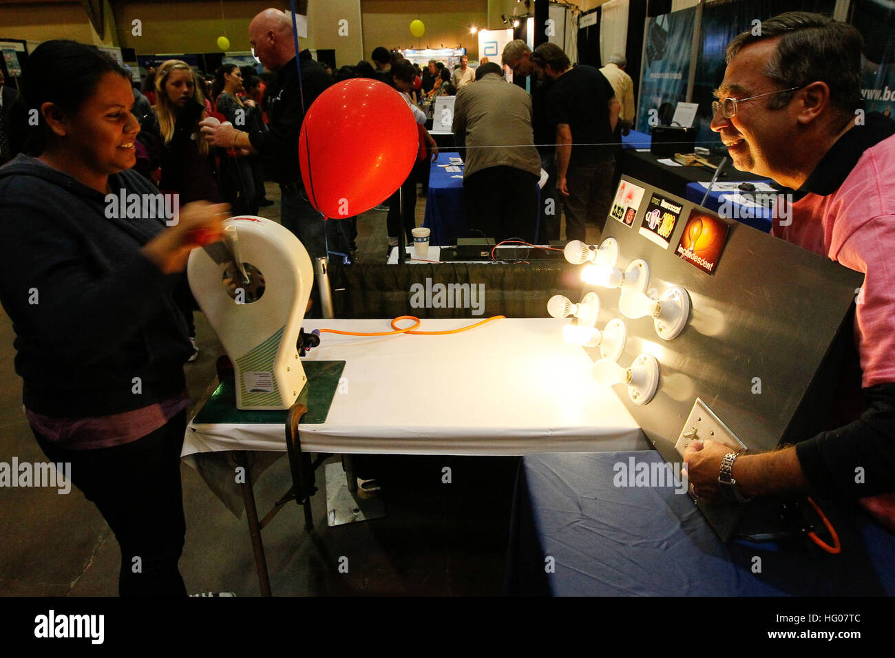 A student demonstrates a hand-crank electrical generator to power small ...