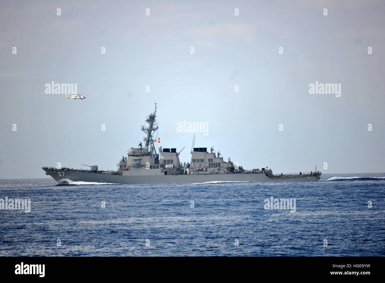 An MH-60R Sea Hawk helicopter from HSM-70 flies above USS Mitscher, a ...