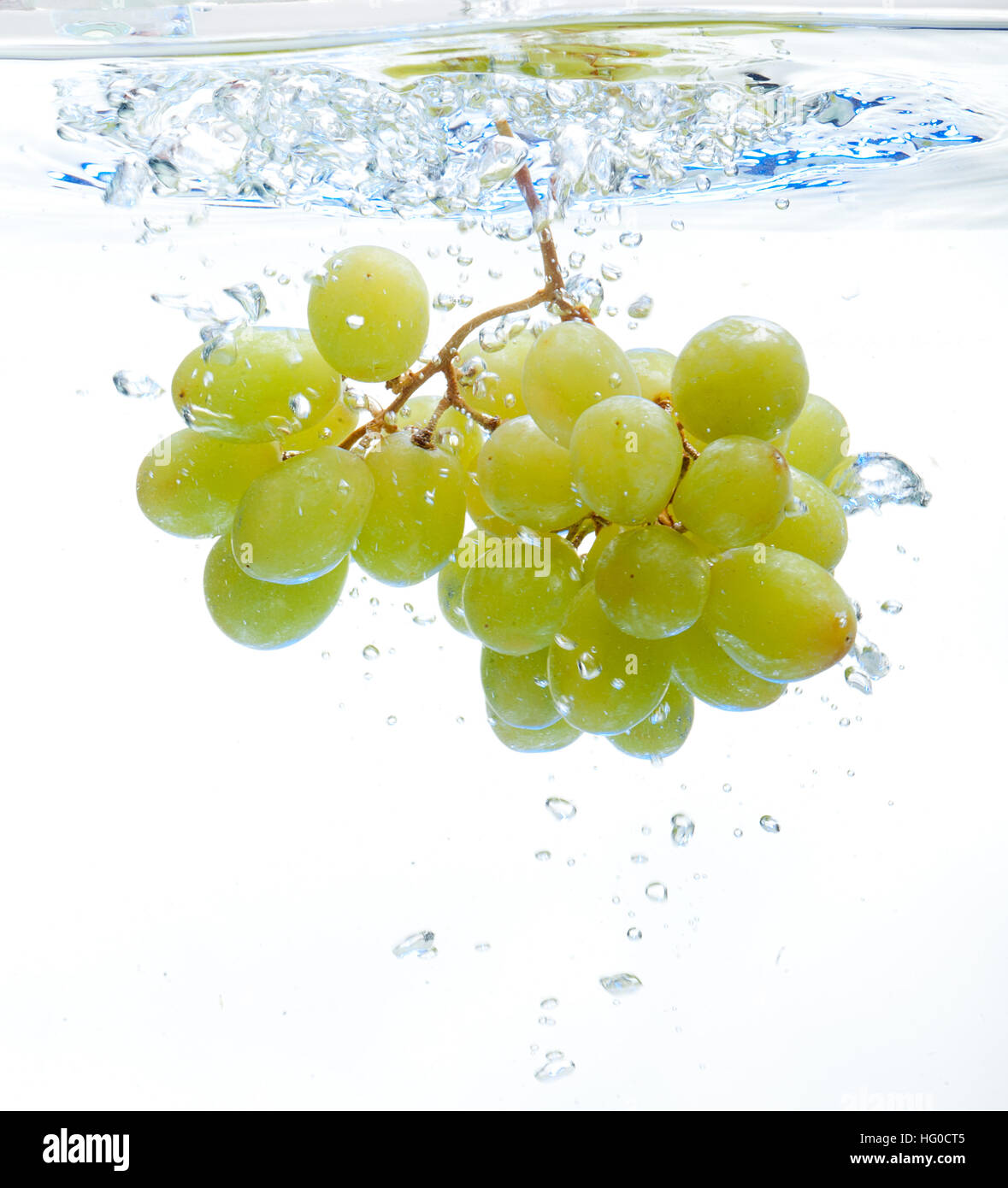 Grapes floating in the water on a white background Stock Photo - Alamy