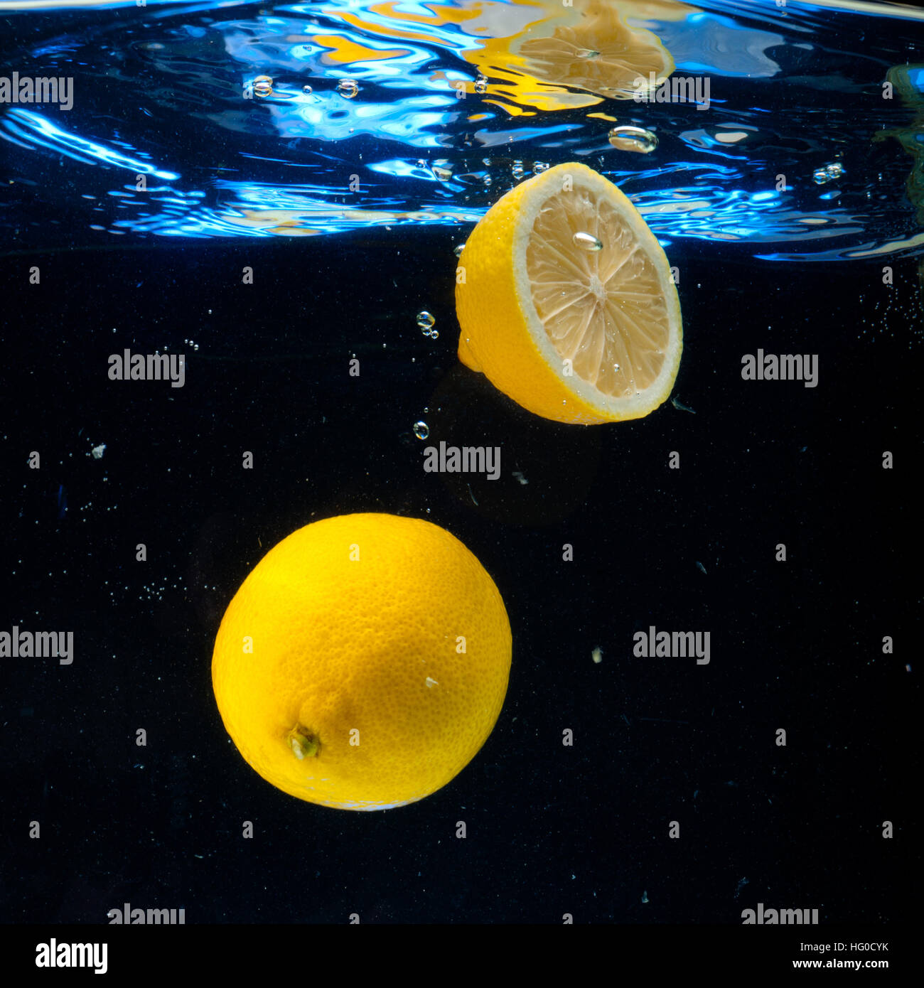 Lemons floating in the water on a black background Stock Photo - Alamy