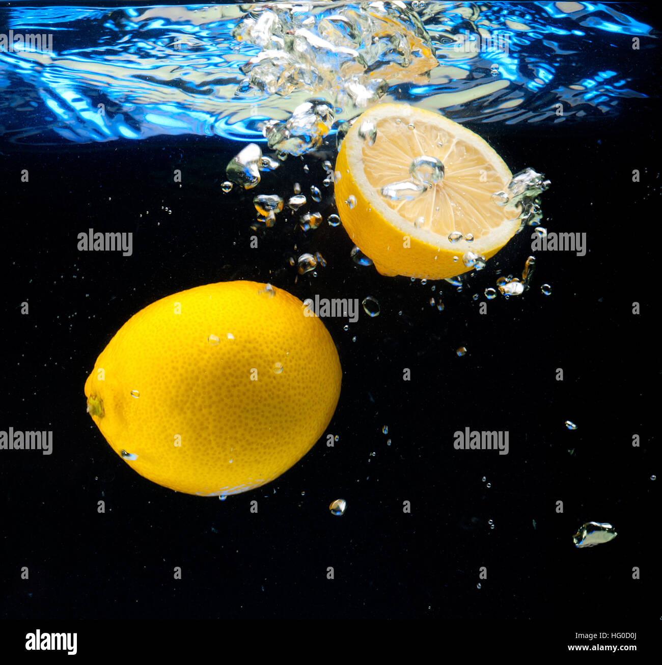 Lemons floating in the water on a black background Stock Photo - Alamy