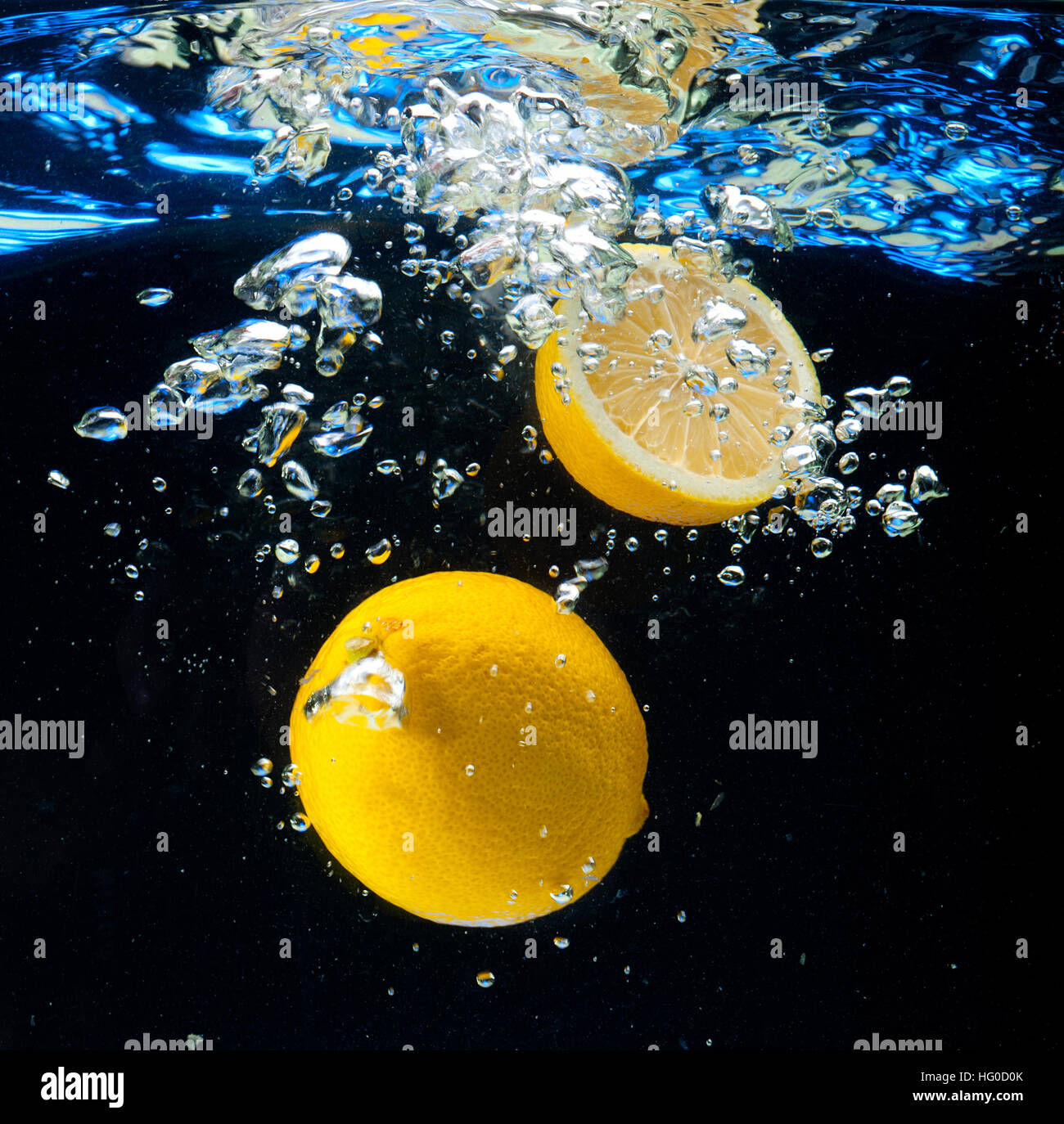 Lemons floating in the water on a black background Stock Photo - Alamy