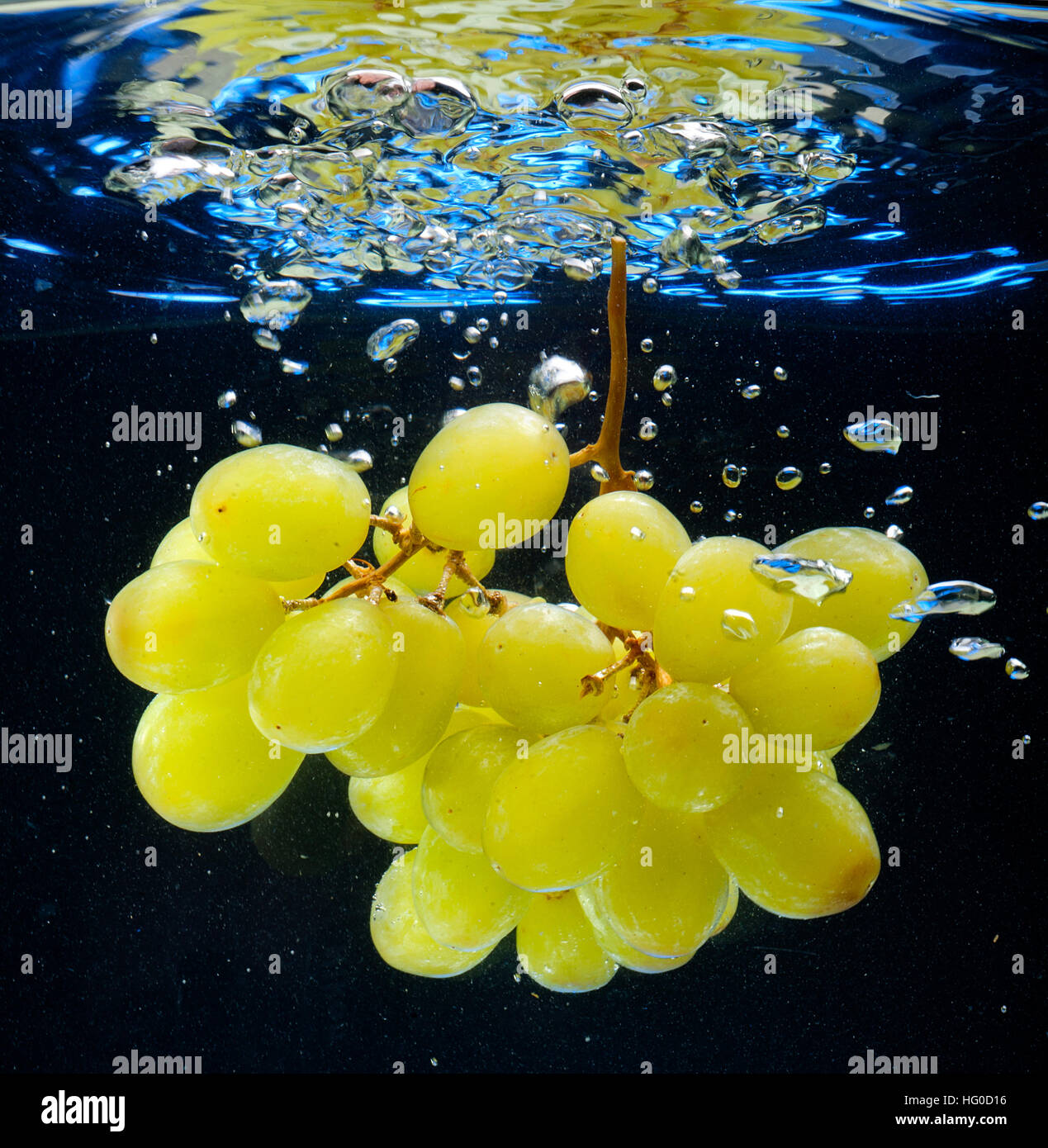 Grapes floating in the water on a black background Stock Photo - Alamy