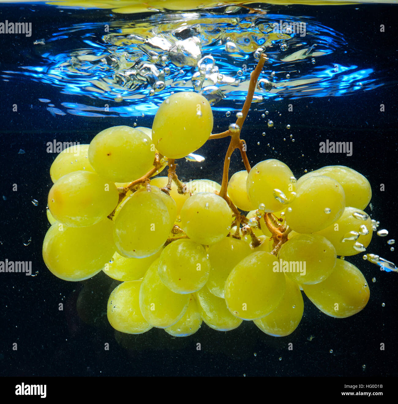 Grapes floating in the water on a black background Stock Photo - Alamy
