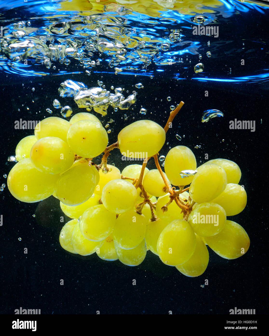 Grapes floating in the water on a black background Stock Photo - Alamy