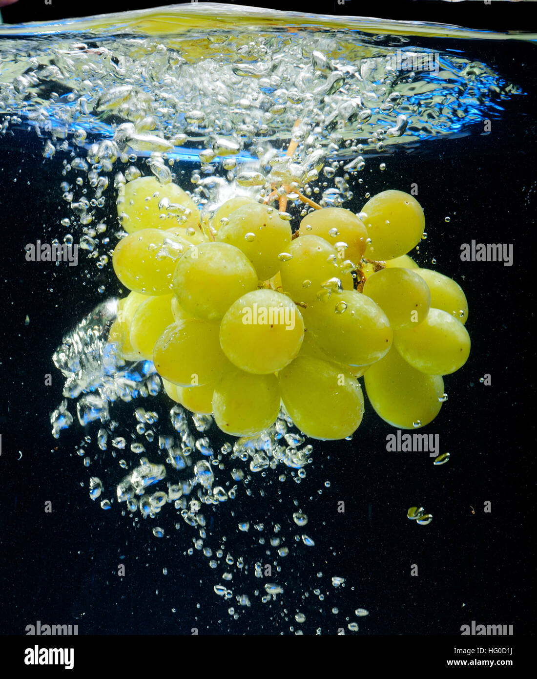 Grapes floating in the water on a black background Stock Photo - Alamy