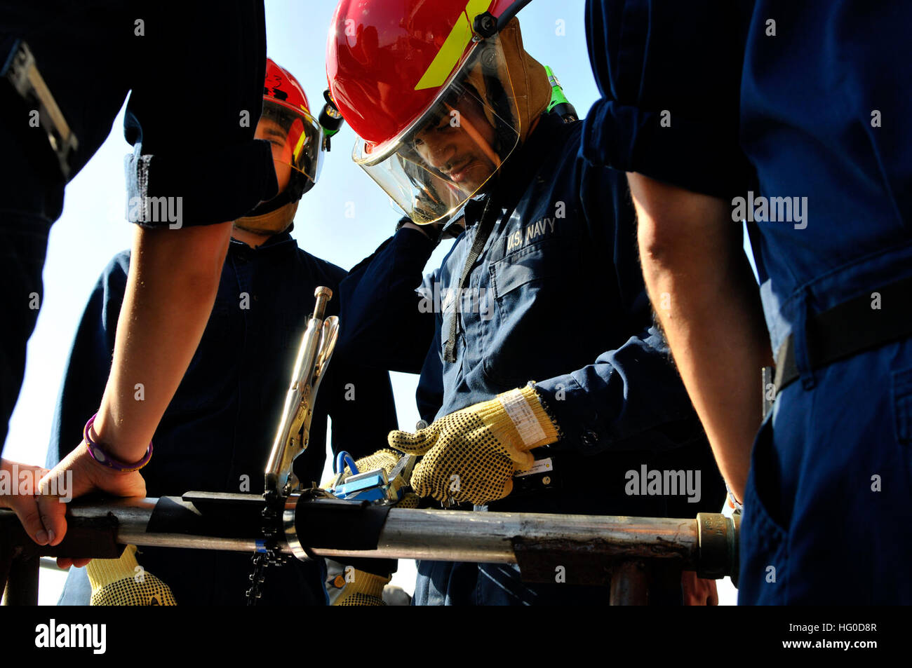 A Damage Controlman practices pipe patching during a firefighting drill ...