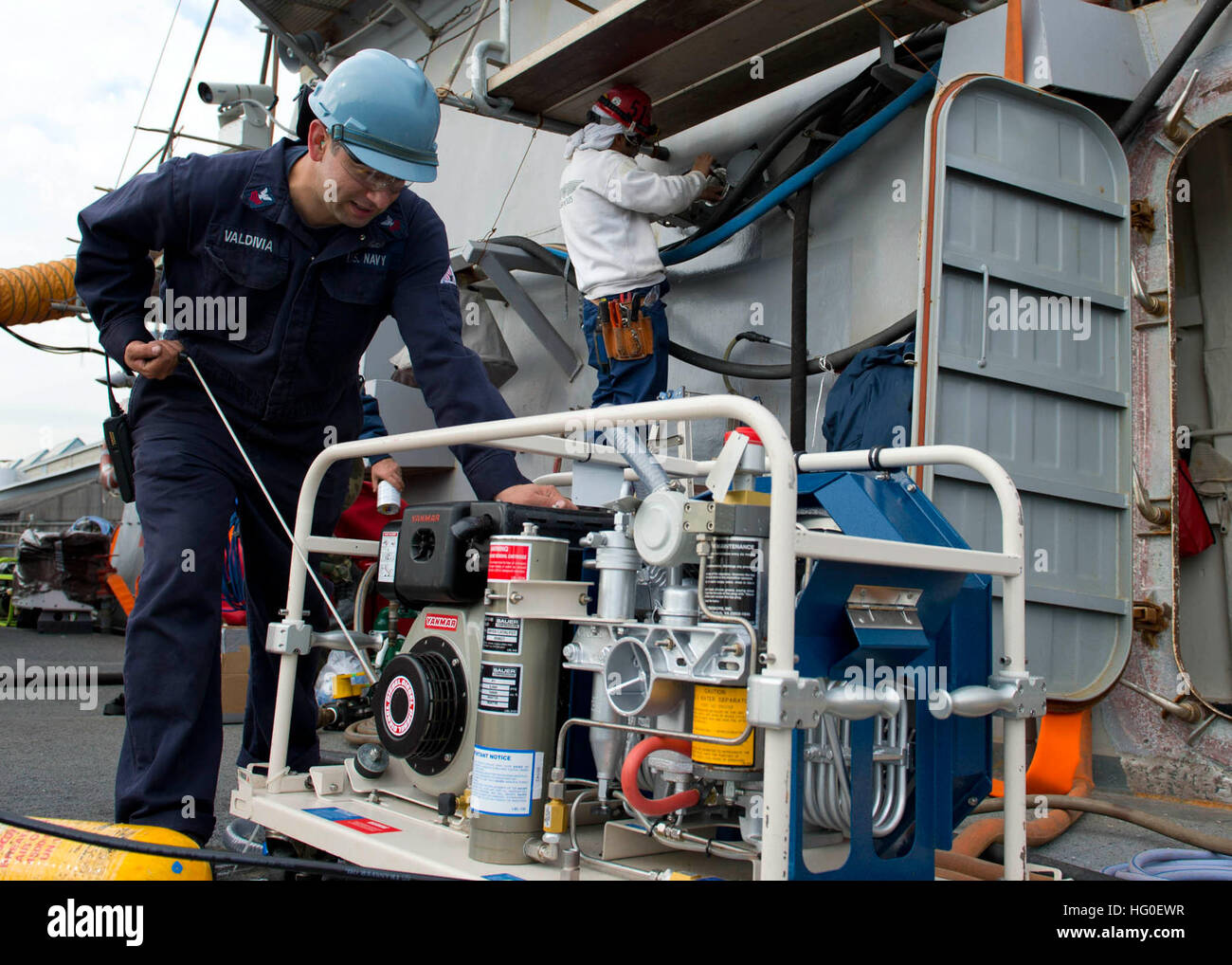 U.S. Navy Damage Controlman 1st Class Danny Valdivia refills self ...