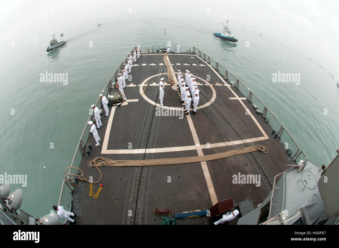 Line handlers stand in formation on the flight deck of the Oliver ...