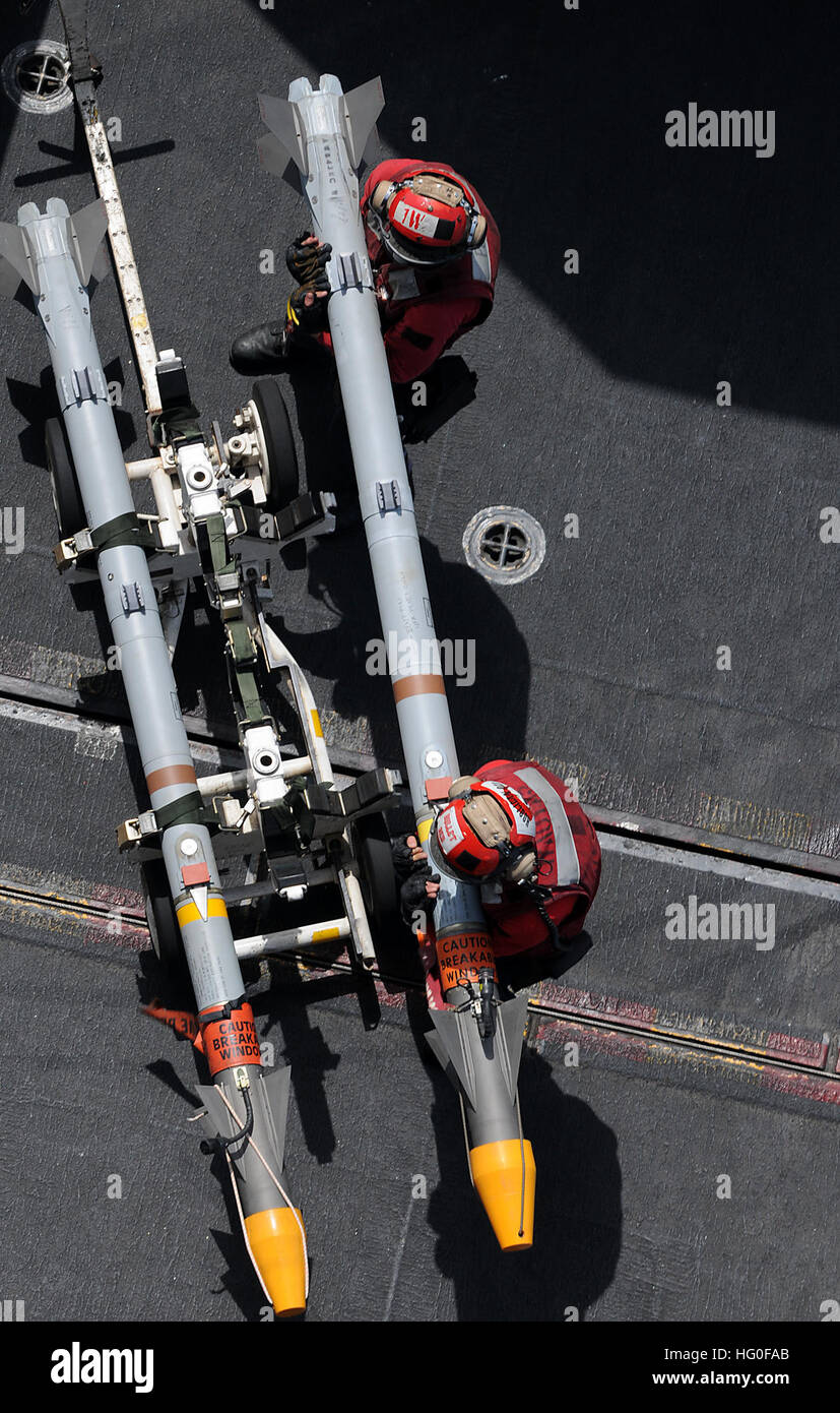 Aviation ordnancemen move ordnance on the flight deck of the Nimitz ...