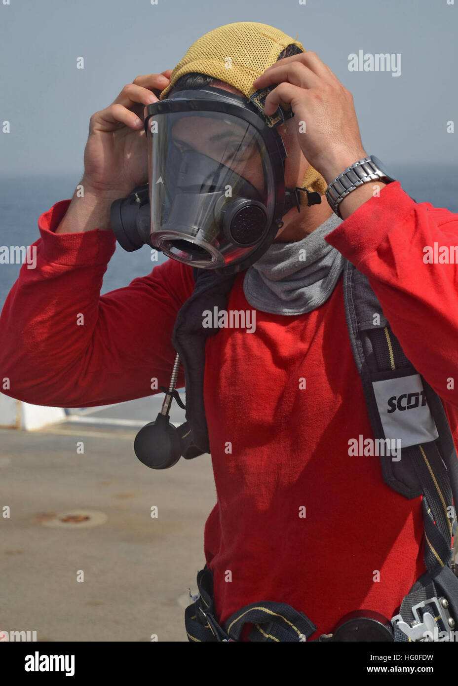 U.S. Navy Ship's Serviceman 3rd Class Srdjan Kremonic dons a self ...