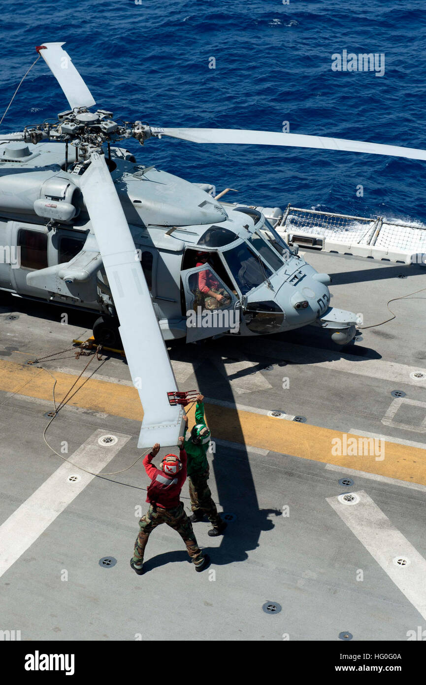Sailors secure rotor blades on an MH-60S Seahawk aboard USS Bonhomme ...
