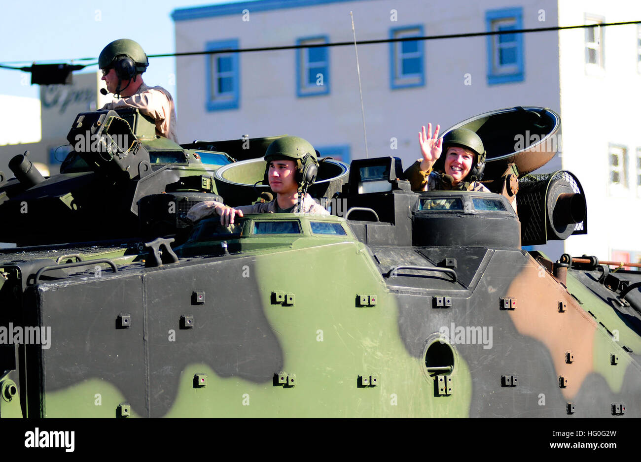 U.S. Marines ride in a tank and wave at the crowd during a parade in ...