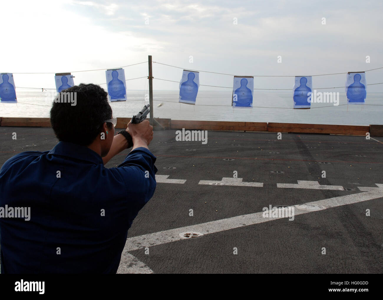 Operations Specialist 3rd Class Tyrone Fletcher shoots a 9mm gun for ...