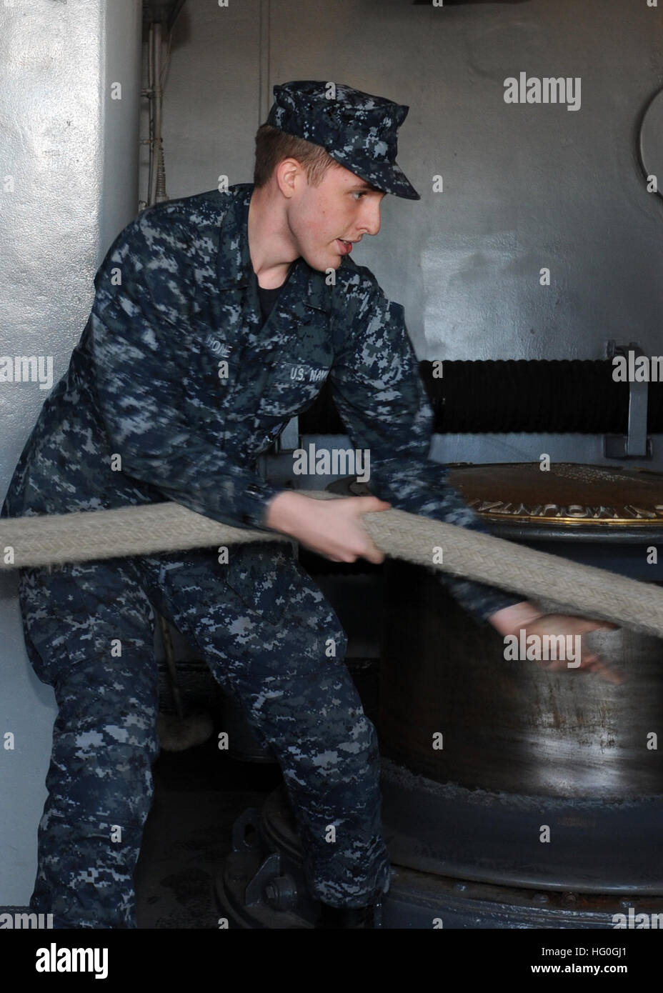U.S. Navy Seaman Recruit Matthew Hone heaves a mooring line aboard the ...
