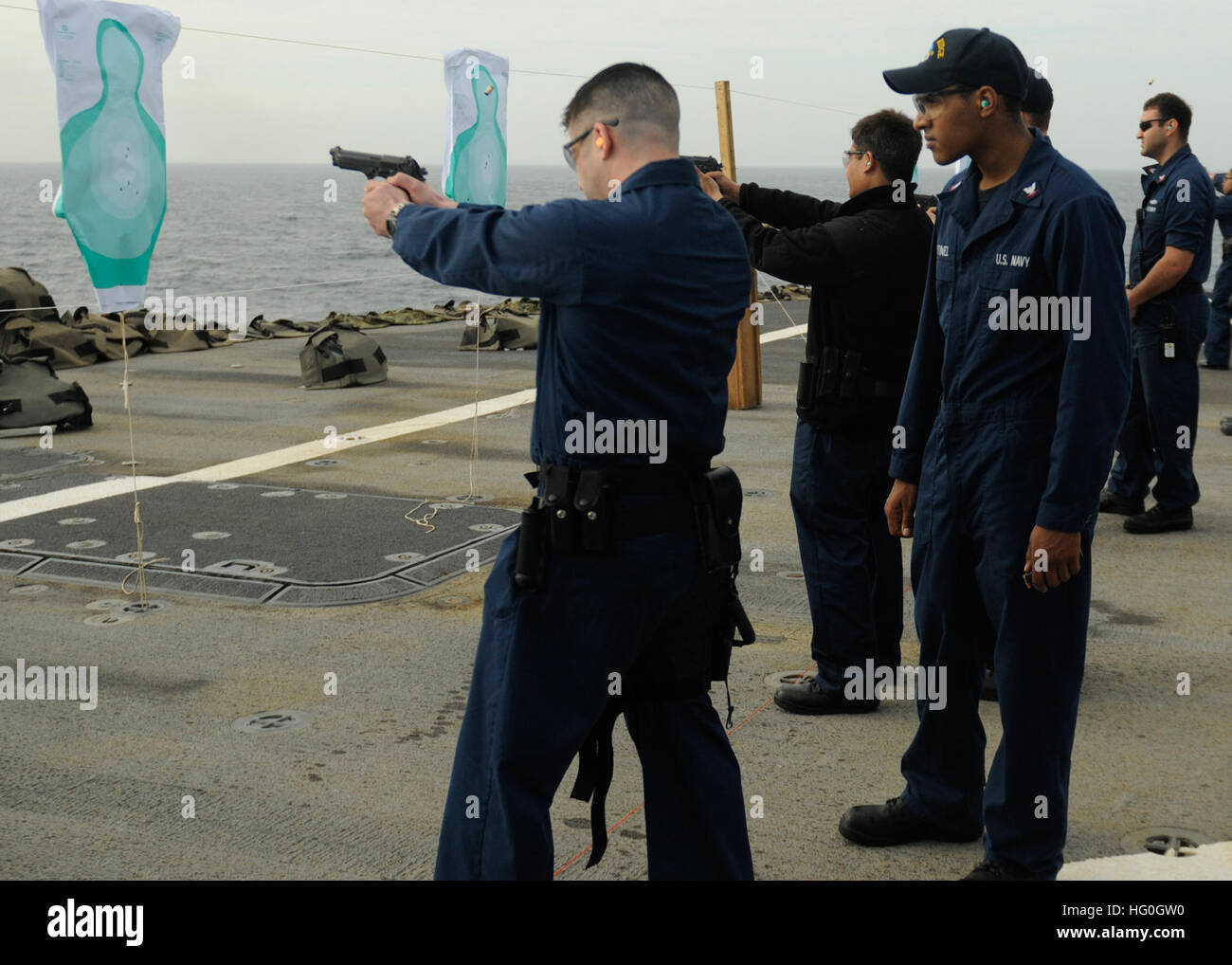 Sailors fire 9 mm pistols during a live-fire exercise on the flight ...